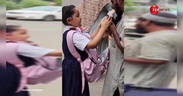 small girl gives her lunch to the beggar while going to school watch ...